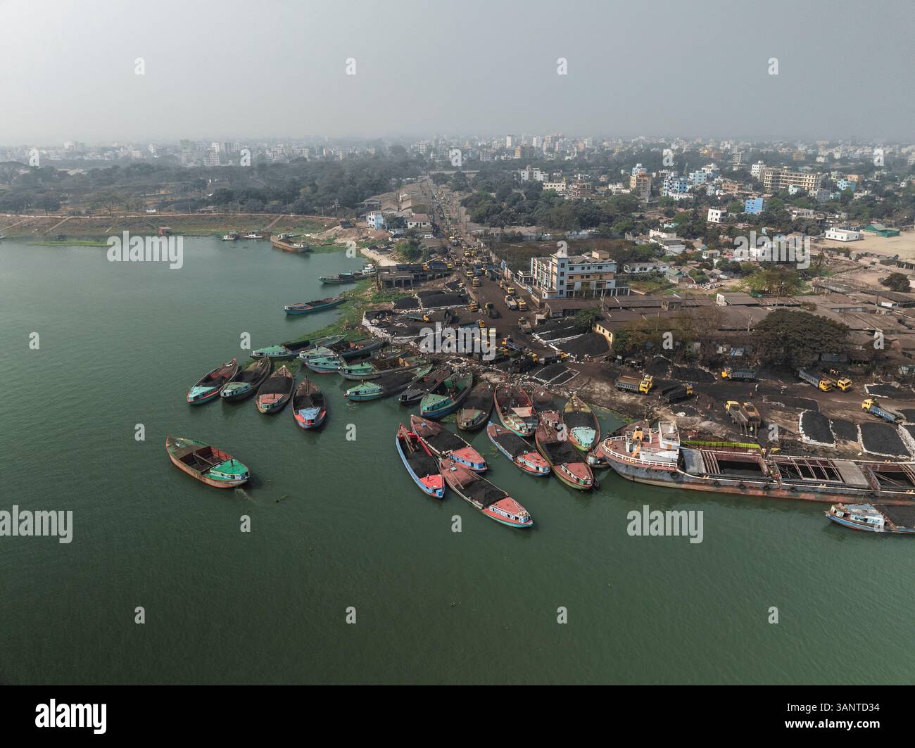 Aerial view of the Meghna River with boats and a coal factory in a ...