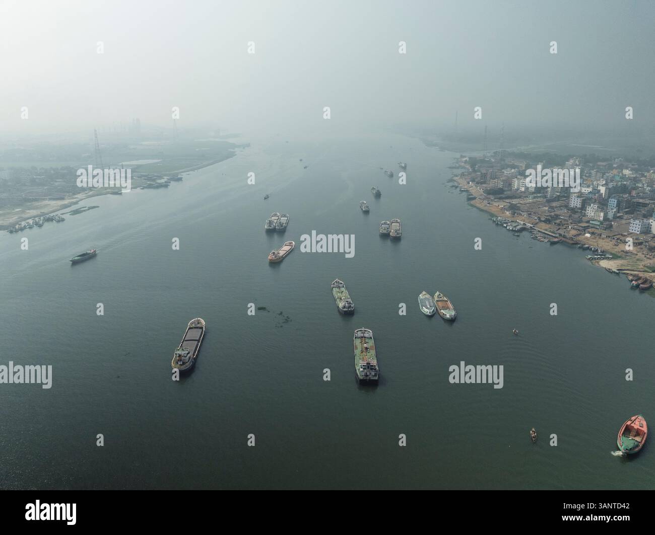 Aerial view of the Meghna River with boats and ships in a hazy urban ...