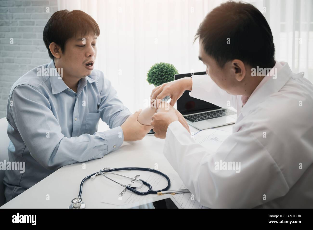 Orthopaedic doctor doing physical examination patient with wrist pain ...
