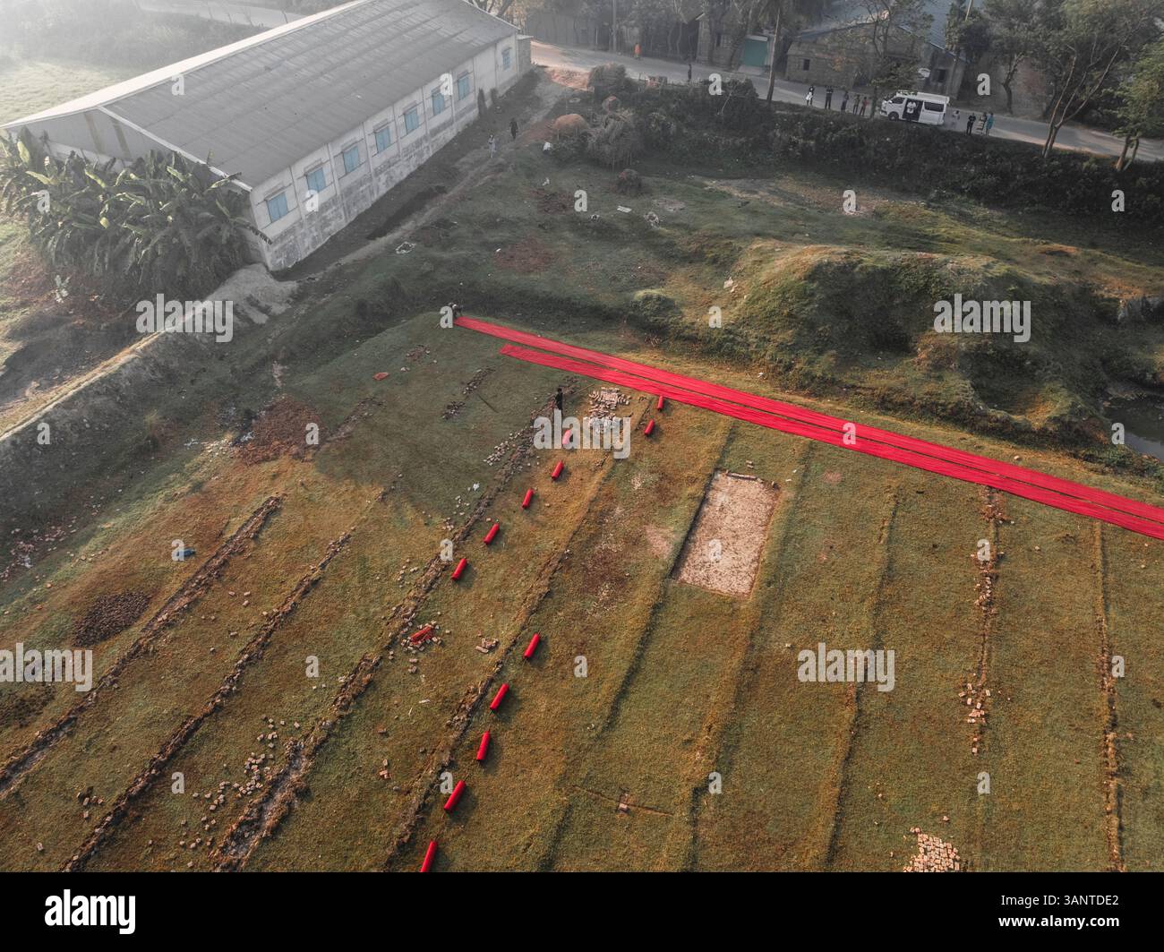Aerial view of people drying cloth in a fabric factory surrounded by ...