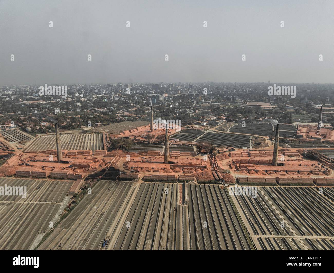Aerial view of industrial brick fields and factory with smokestacks and ...