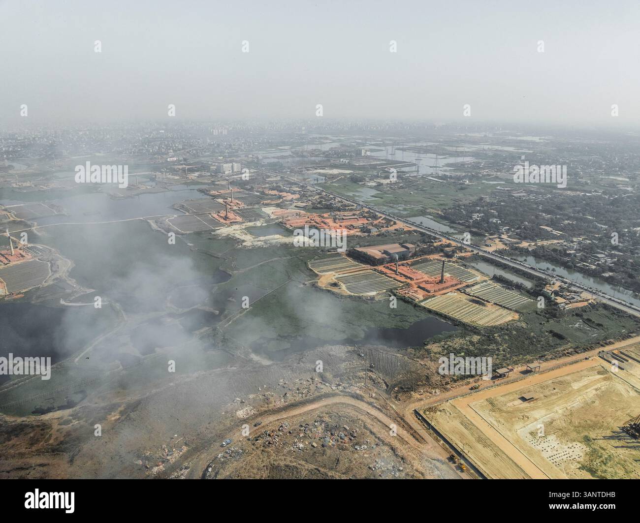 Aerial view of industrial brick fields and factories with smoke and ...