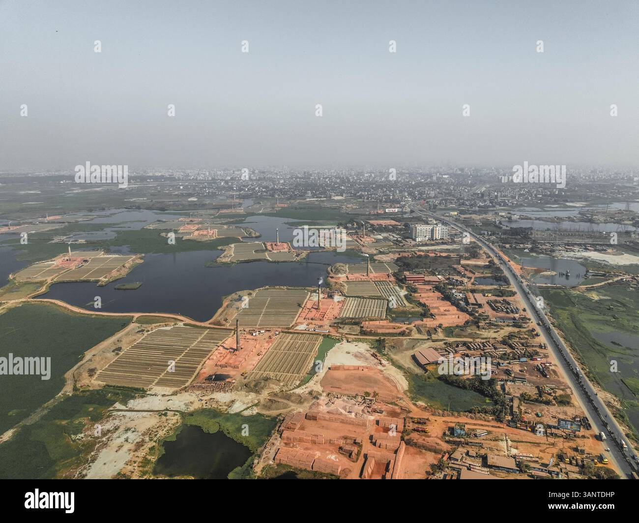 Aerial view of beautiful brick fields and factory amidst urban ...