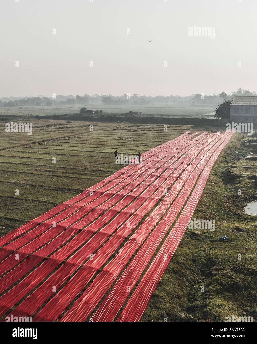 Aerial view of a cloth factory with people drying red cloth in vibrant ...