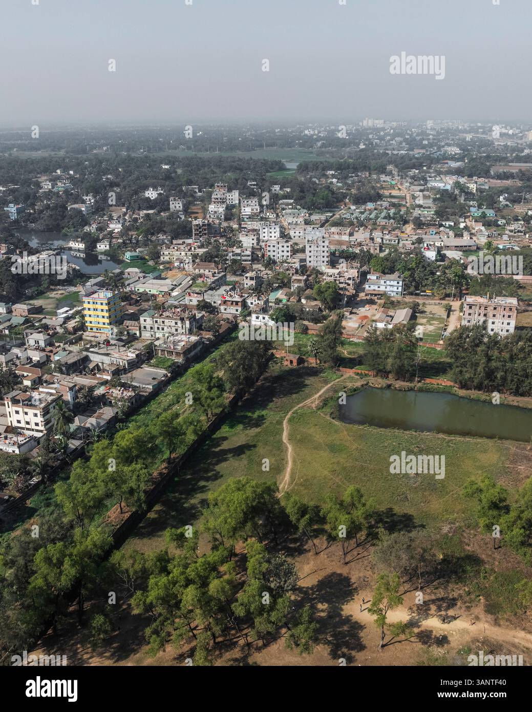 Aerial view of urban landscape with dense buildings, greenery, and a ...