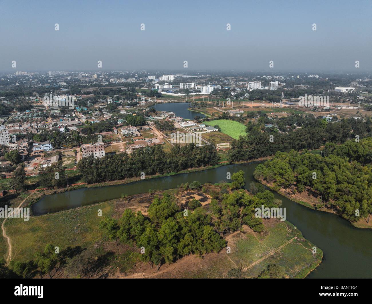 Aerial view of peaceful suburban landscape with a river, trees, and ...