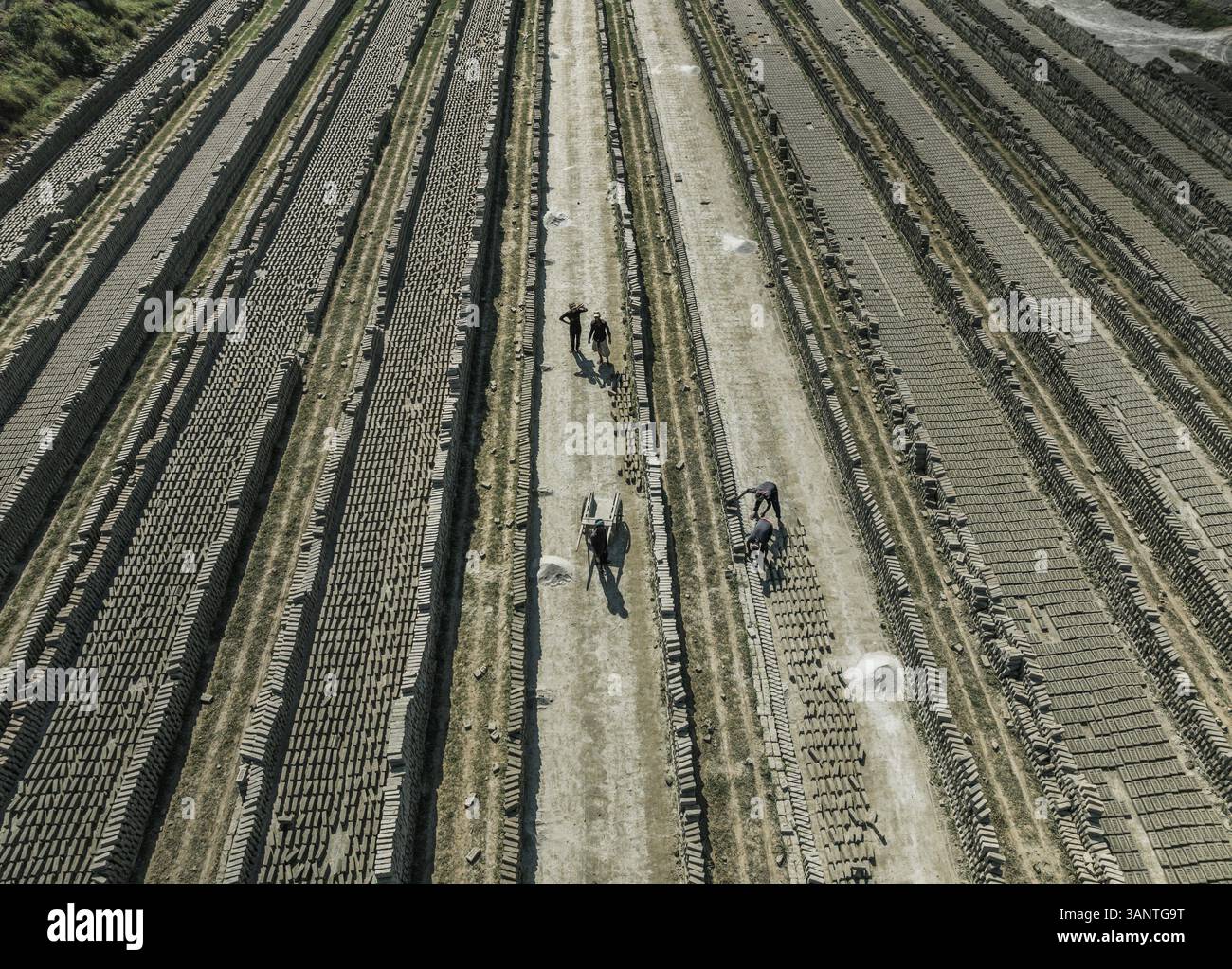 Aerial view of brick fields with workers and factory producing bricks ...