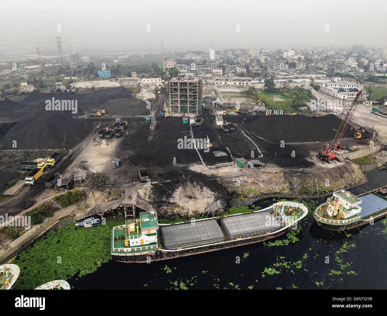 Aerial view of industrial coal factory with cranes and boats along the ...