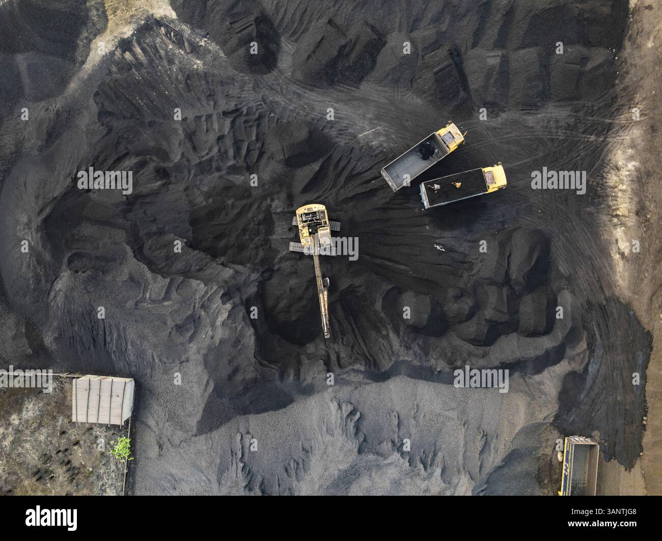 Aerial view of a coal factory with cranes and excavators in a bustling ...
