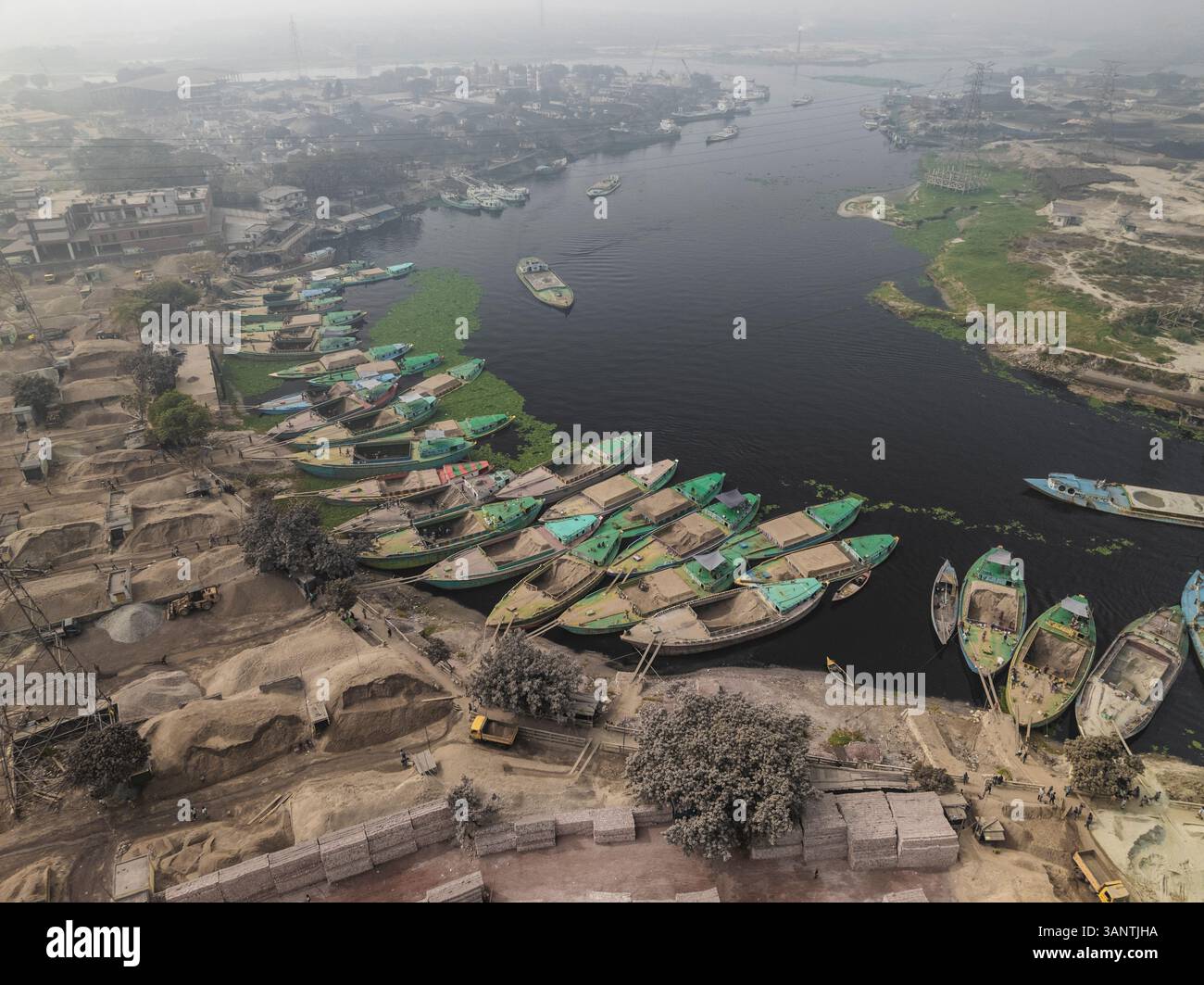 Aerial view of Buriganga river with traditional boats and cement ...