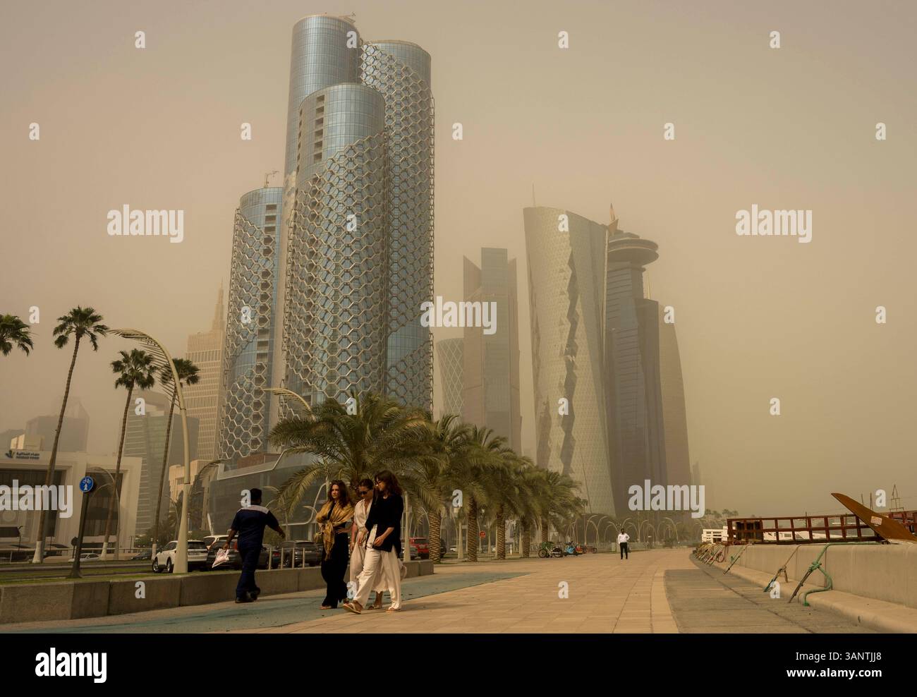 Doha, Qatar. 15th Apr, 2025. People walk in dense dust in Doha, Qatar ...