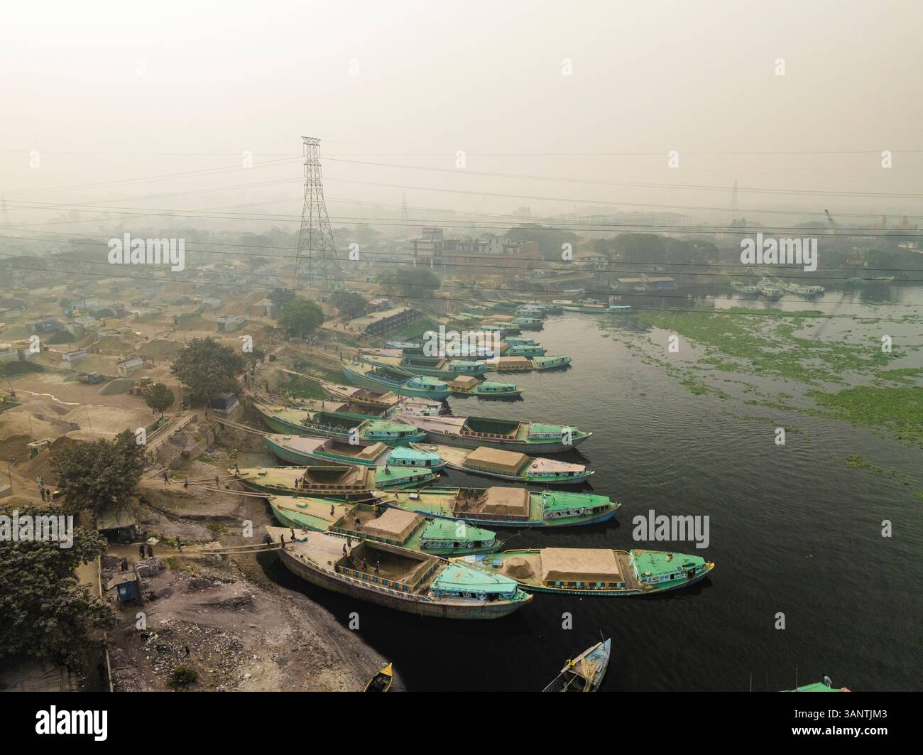 Aerial view of bustling boats and cement industries along the Buriganga ...