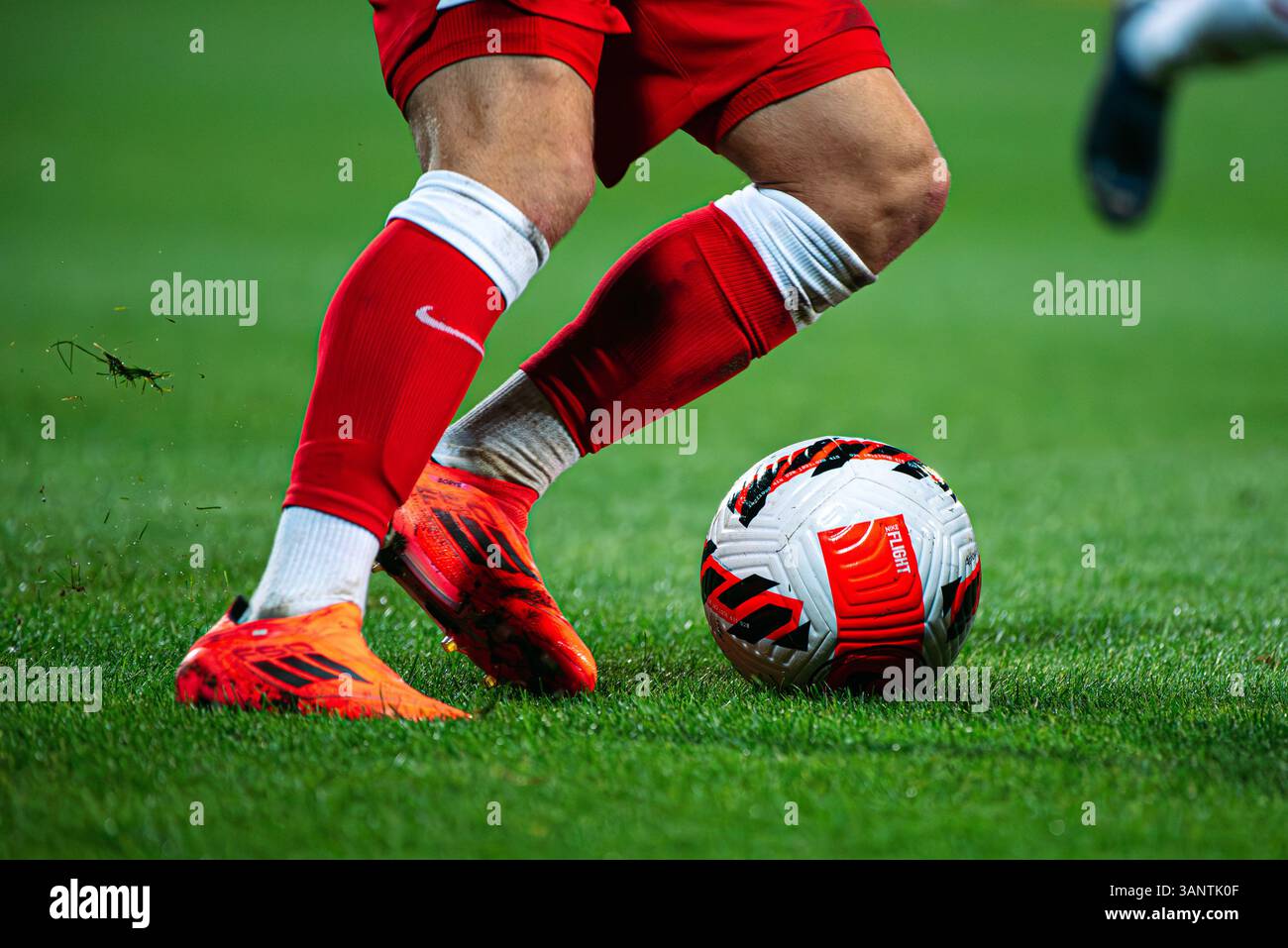 Close-up of a soccer player in red kit and Nike-branded socks ...