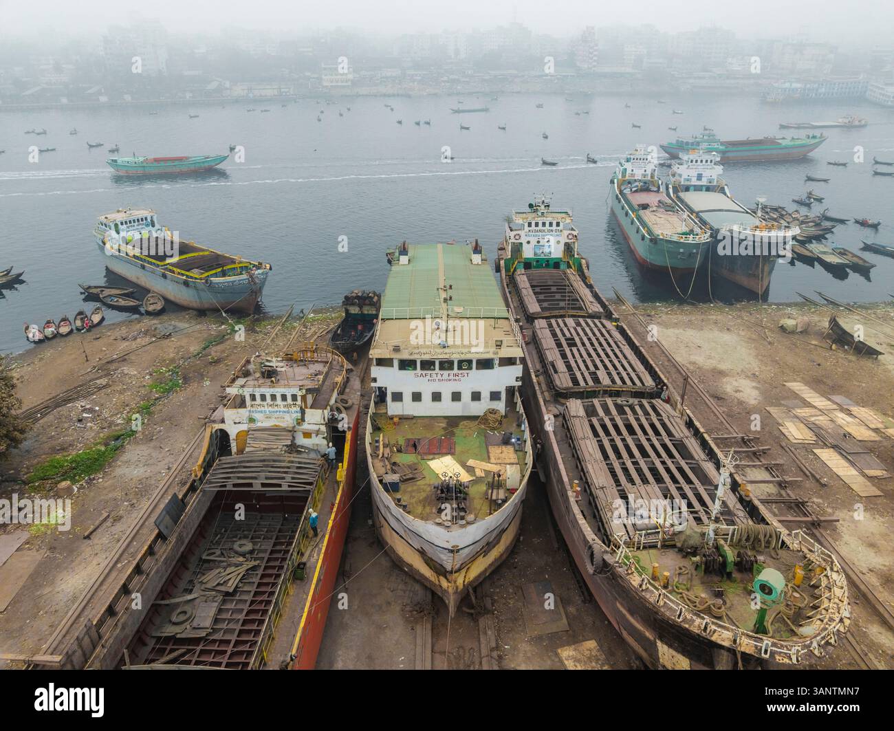 Aerial view of a bustling shipyard with various ships and boats along ...