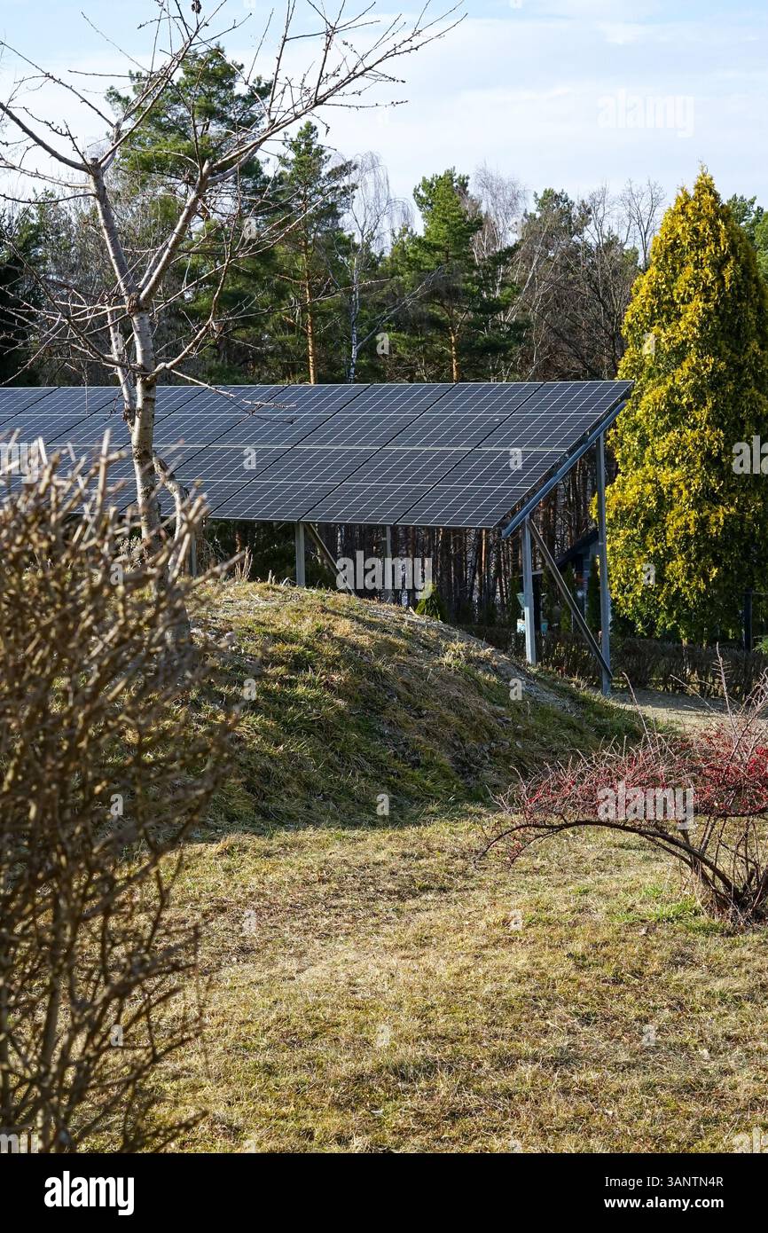Solar panel installation in a rural area, surrounded by greenery and ...