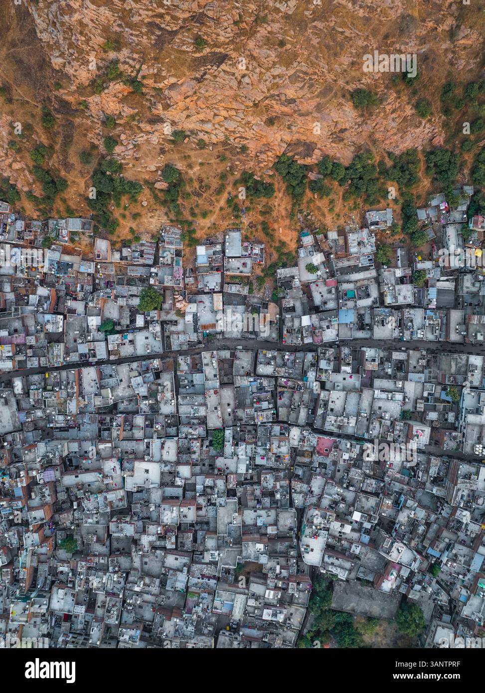 Aerial view of densely packed buildings and rooftops with a hillside ...