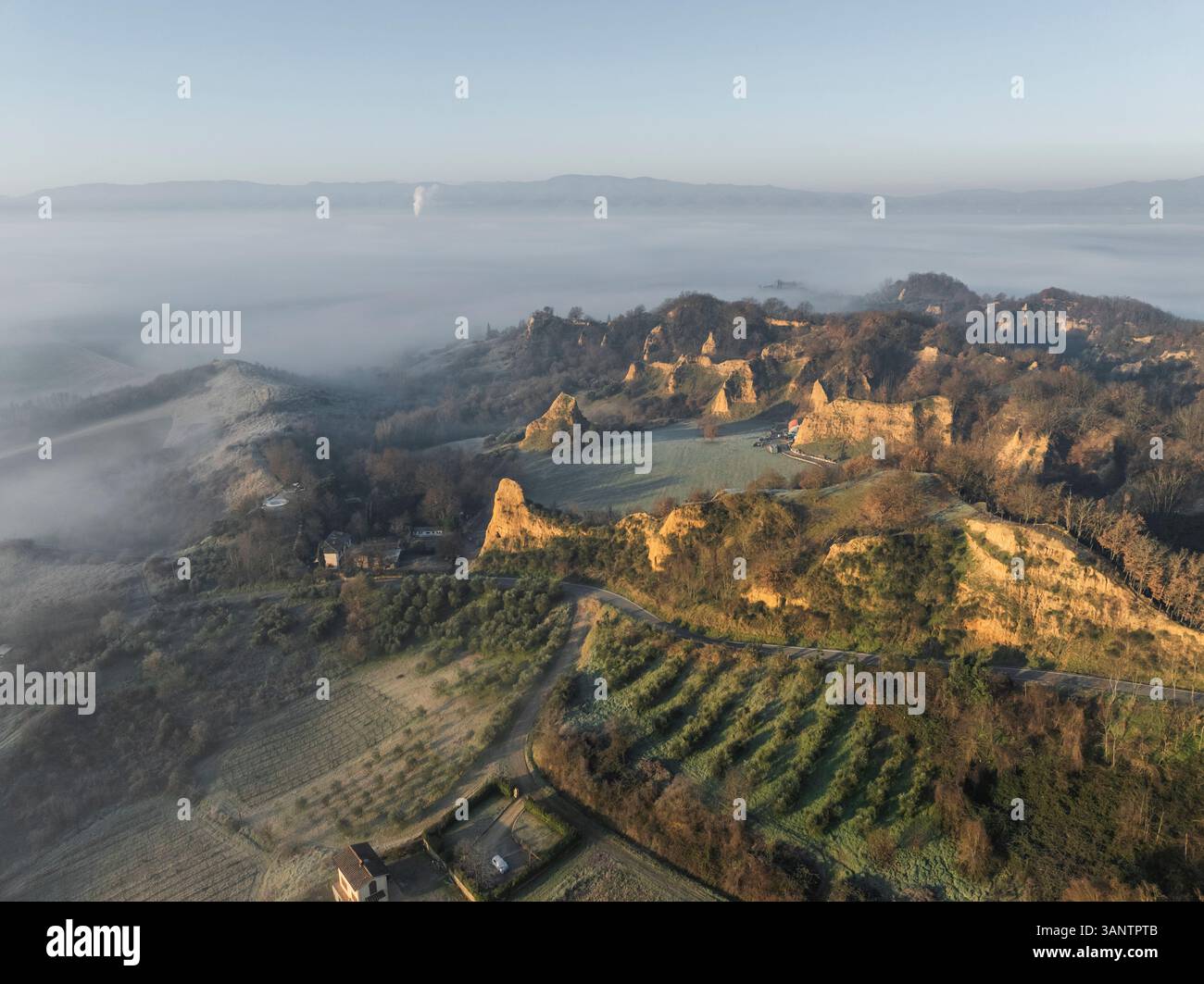 Aerial view of balze valdarno shrouded in fog and mist at sunrise ...