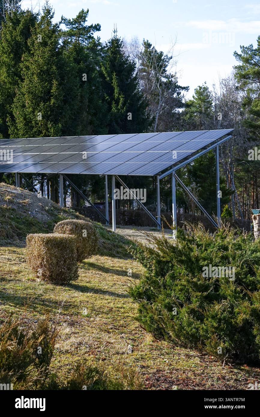 Solar panel installation in a rural area, surrounded by greenery and ...
