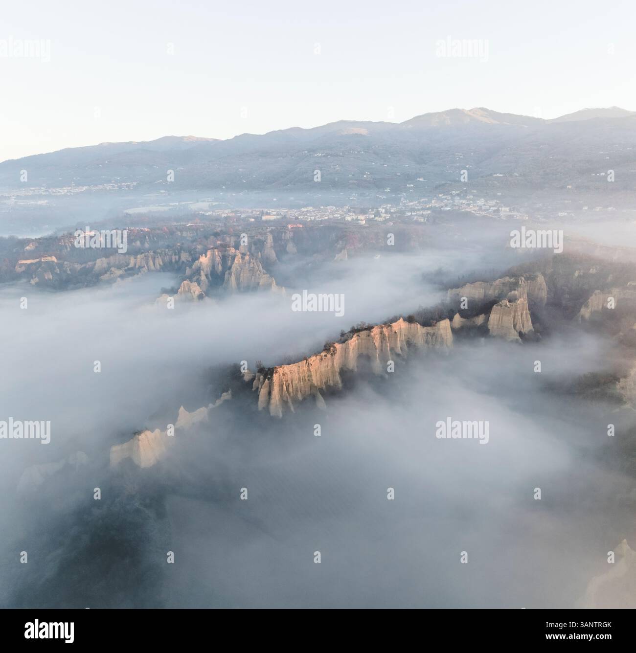 Aerial view of balze valdarno shrouded in fog and mist at sunrise ...