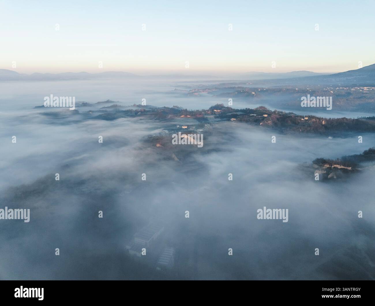 Aerial view of balze valdarno shrouded in fog and mist at sunrise ...