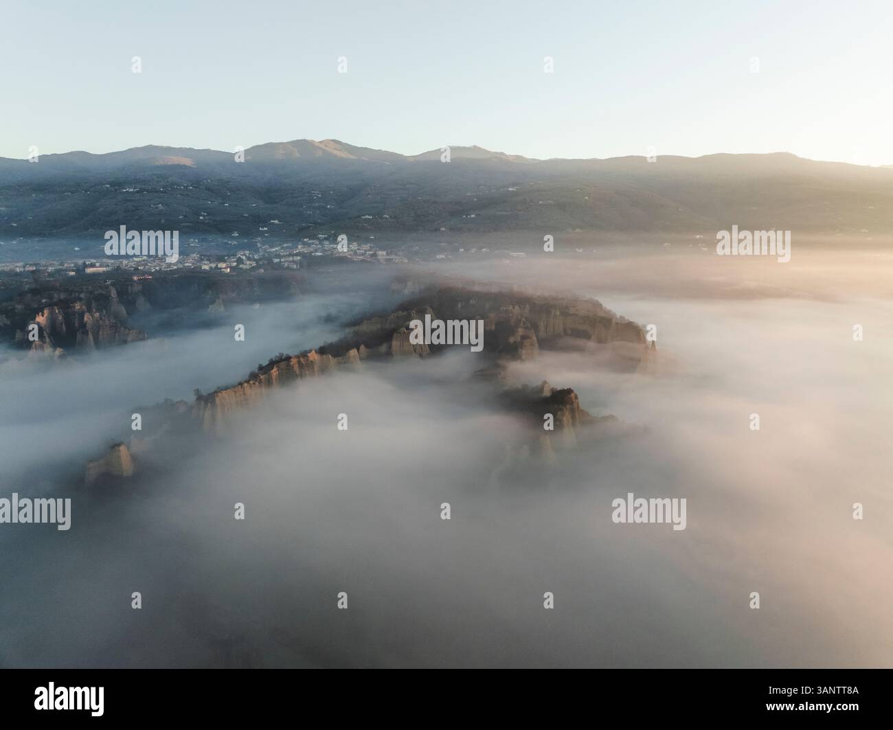 Aerial view of balze valdarno shrouded in fog and mist at sunrise ...