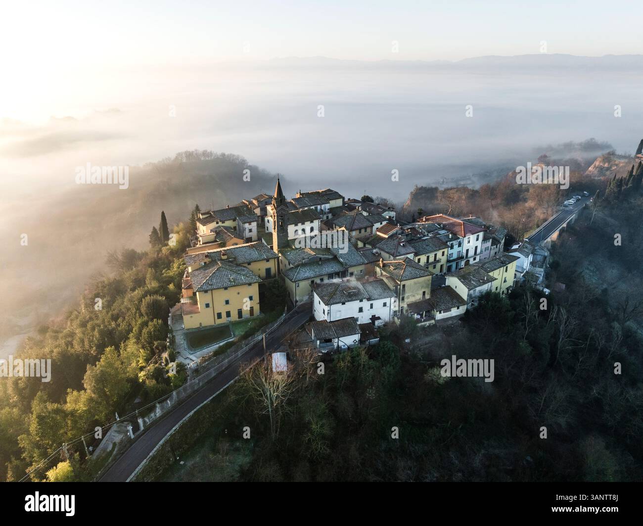 Aerial view of the medieval village shrouded in fog at sunrise with ...