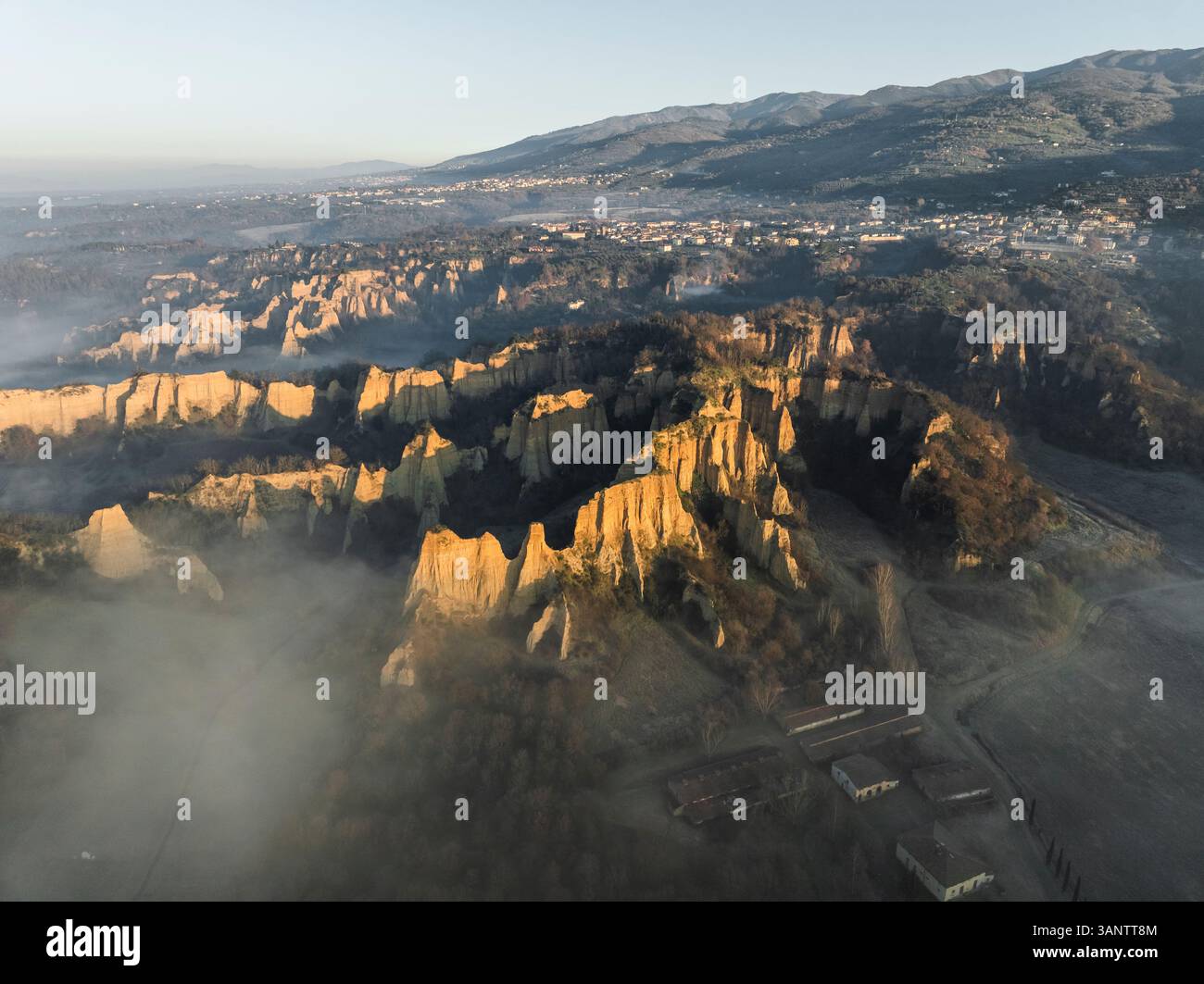 Aerial view of balze valdarno covered in fog and mist at sunrise ...