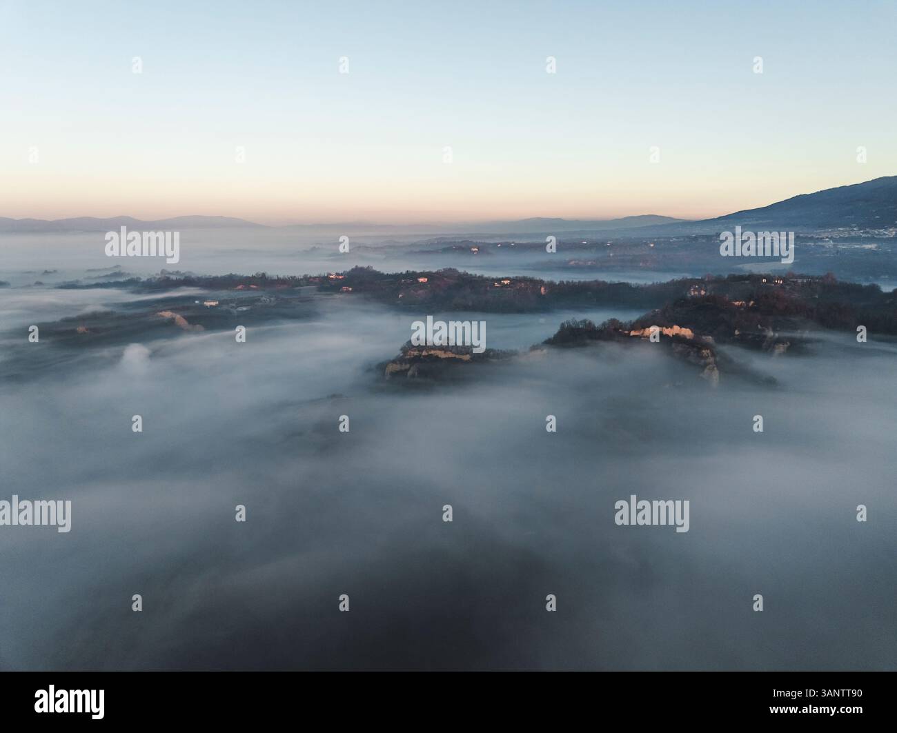 Aerial view of balze valdarno shrouded in fog and mist at sunrise ...