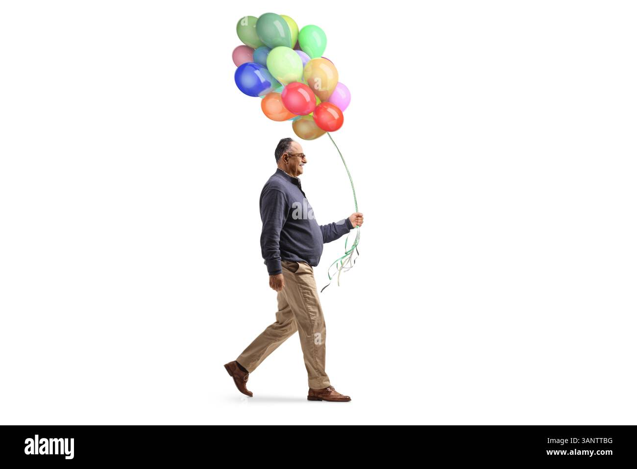 Full length profile shot of a mature man walking with a bunch of ...