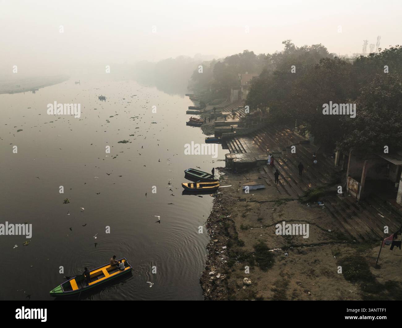 Aerial view of tranquil Yamuna Ghat with boats and birds along the ...