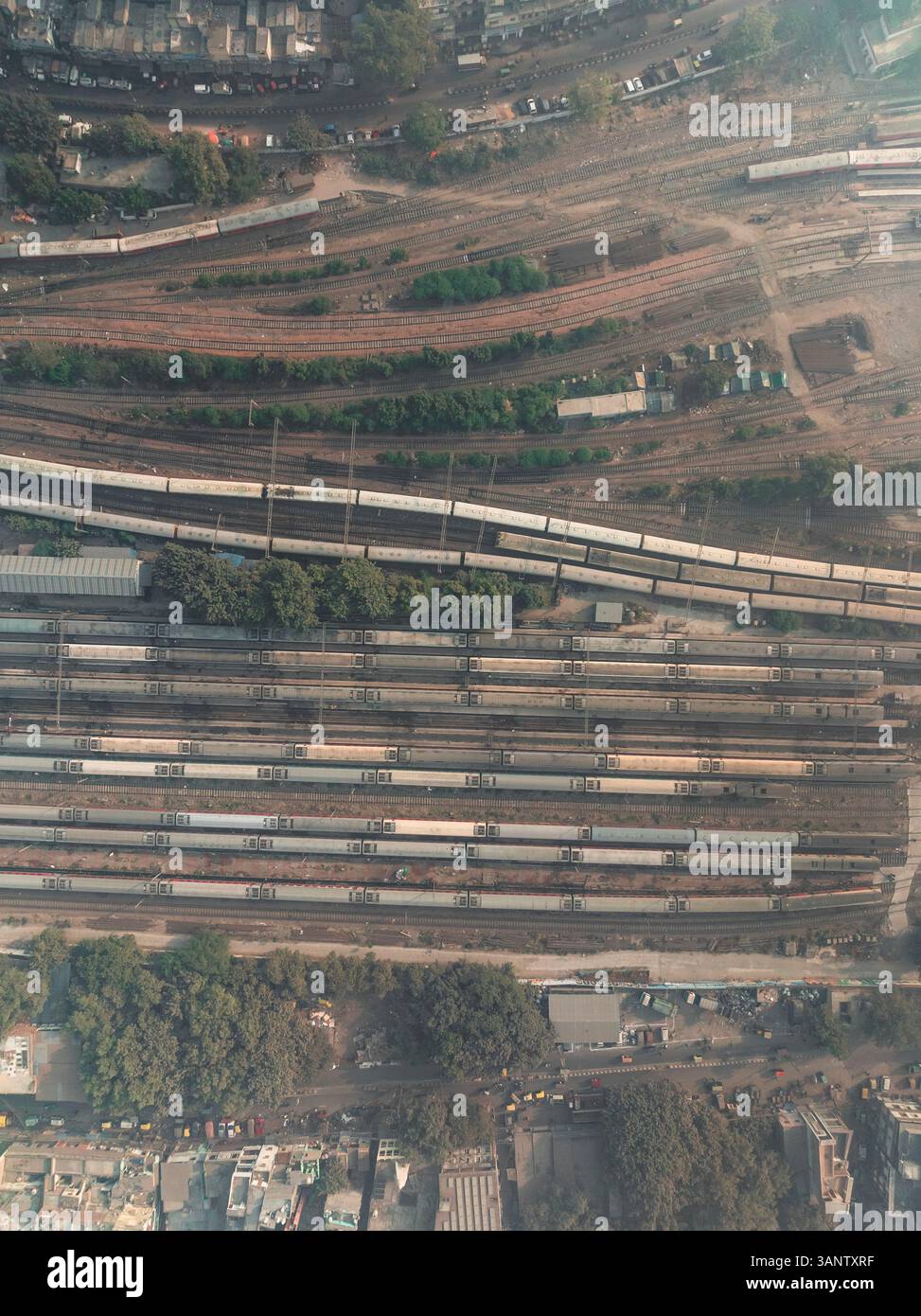 Aerial view of busy train station with organized tracks and dense urban ...