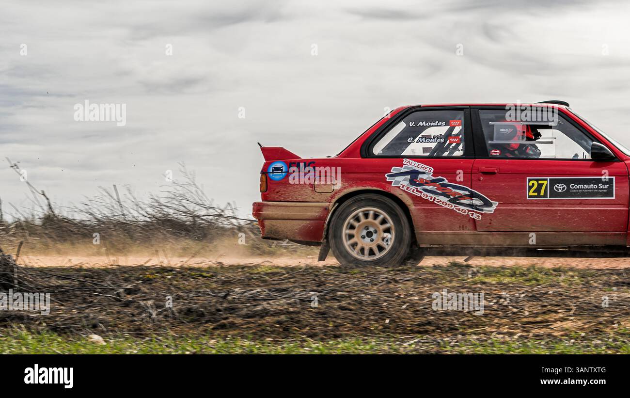 Madrid, Spain; 02-15-2025: Rear view of a red BMW 325i E30 rally car competing on a dusty track ...