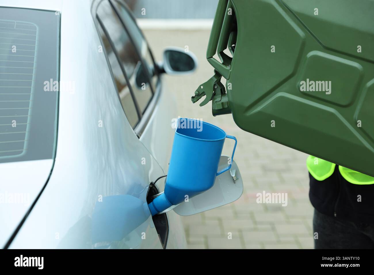 Man pouring fuel from canister into funnel outdoors, closeup Stock ...