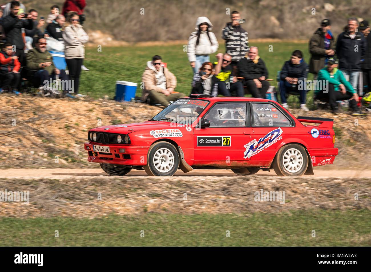 Madrid, Spain; 02-15-2025: Classic red BMW 325i E30 rally car competing on winding dirt roads in ...