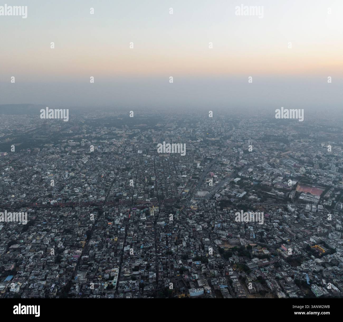 Aerial view of expansive cityscape at sunset with dense buildings and ...