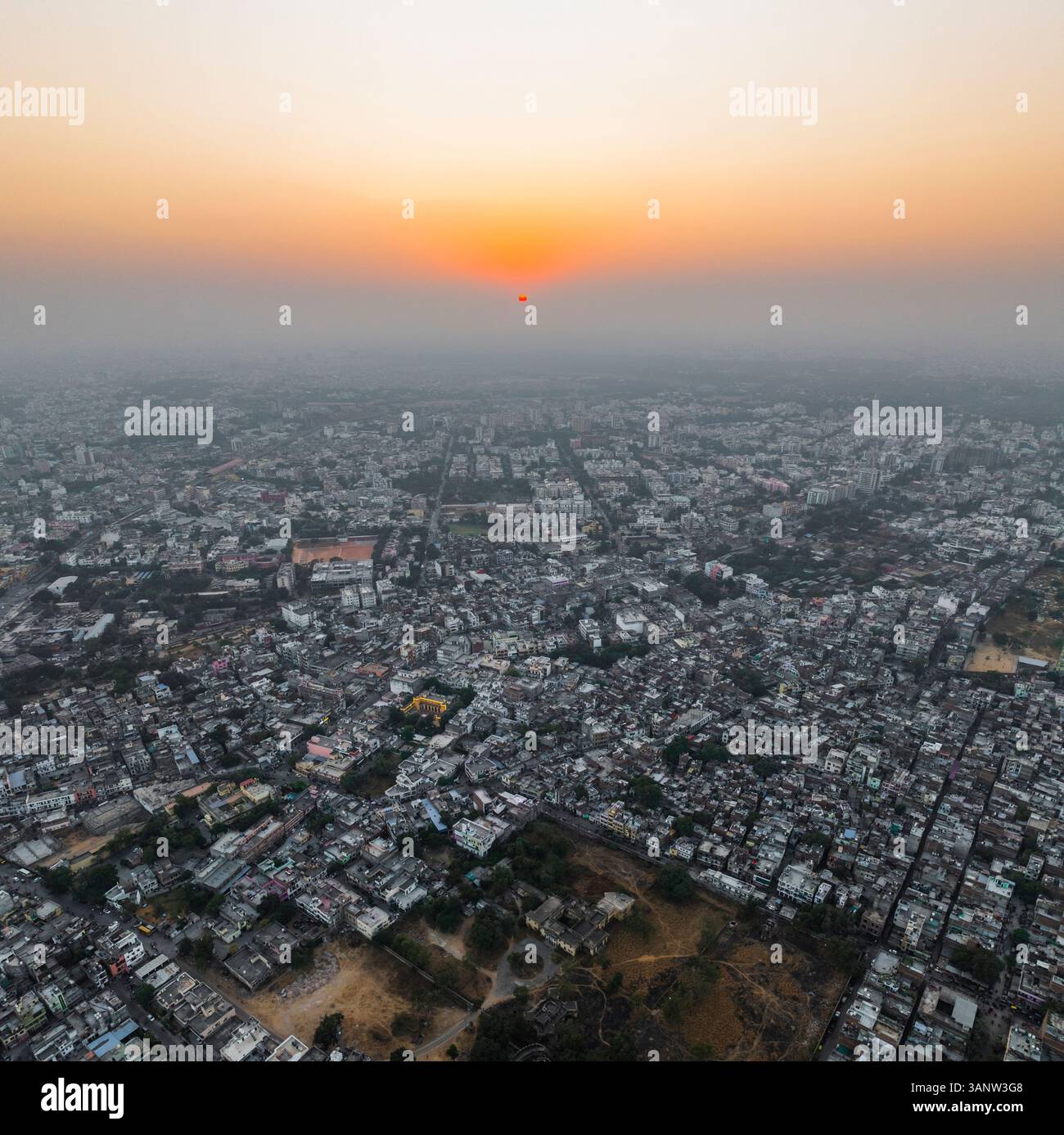 Aerial view of vibrant cityscape at sunset with sprawling buildings and ...