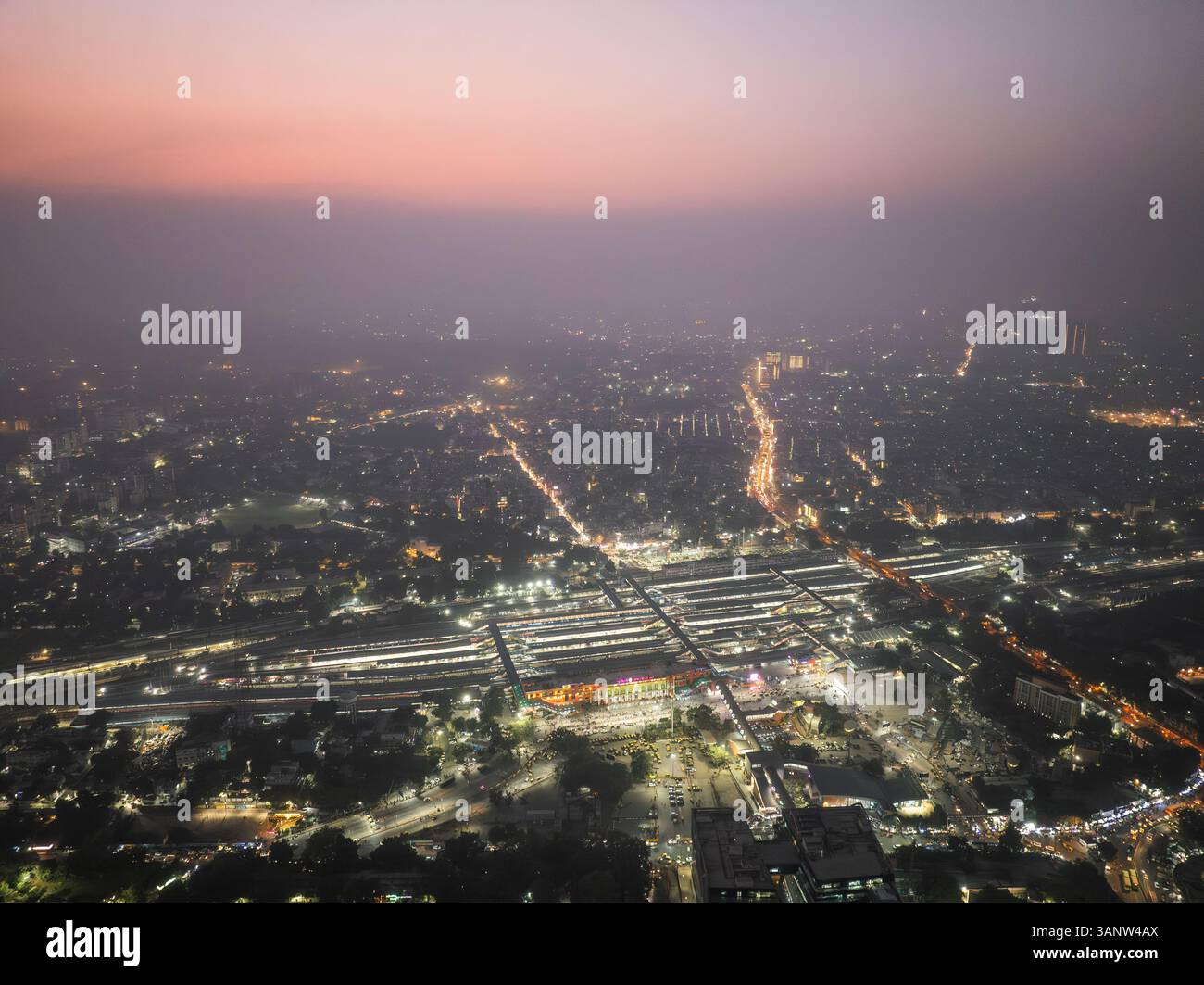 Aerial view of vibrant cityscape with illuminated train station and ...