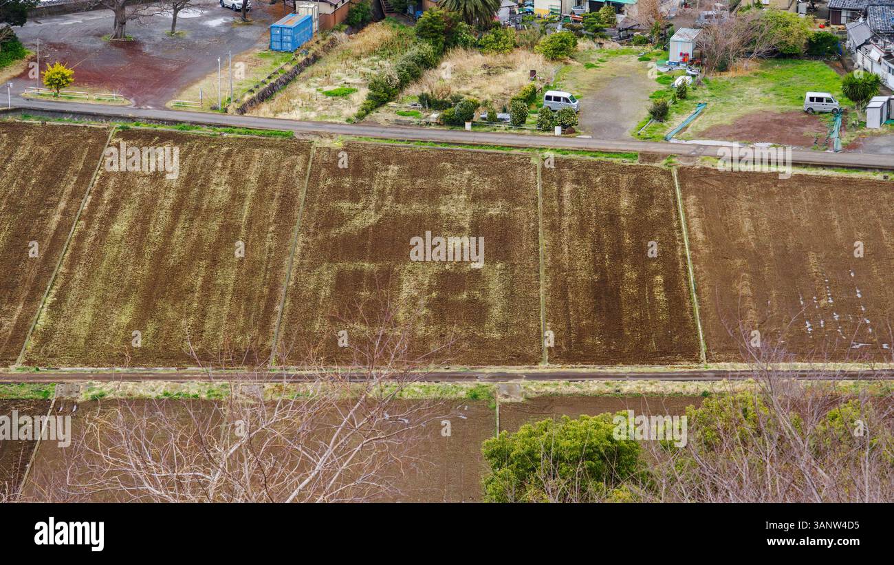 High-angle view of Ita Village name revealed in a fallow rapeseed field ...