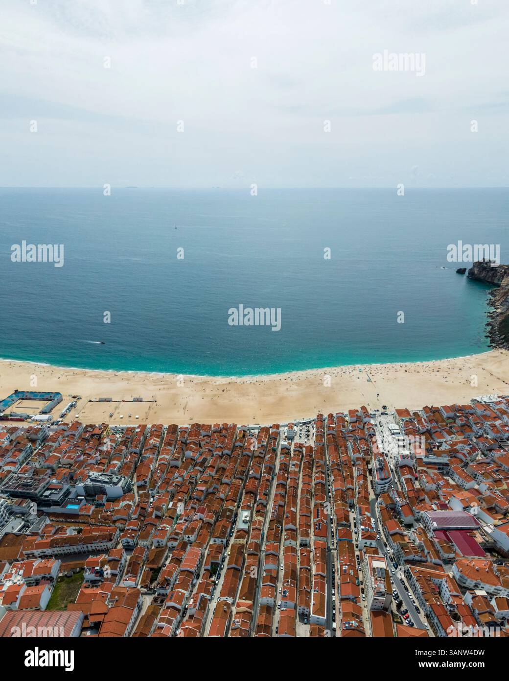 Aerial view of beautiful sandy beach and rooftops in a small town by ...