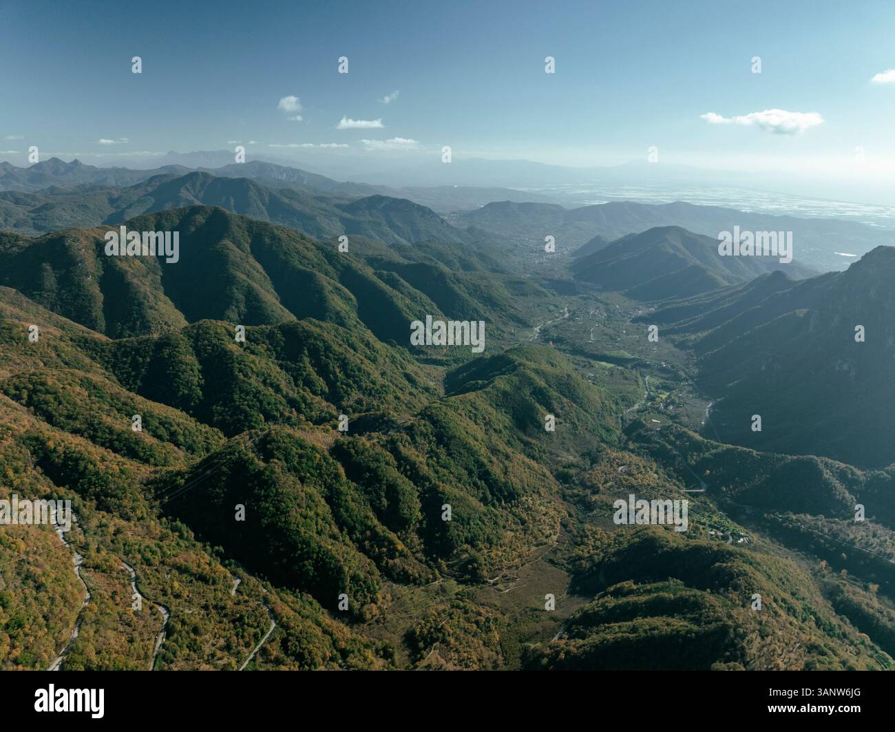 Aerial view of the lush mountains and serene valley surrounded by ...