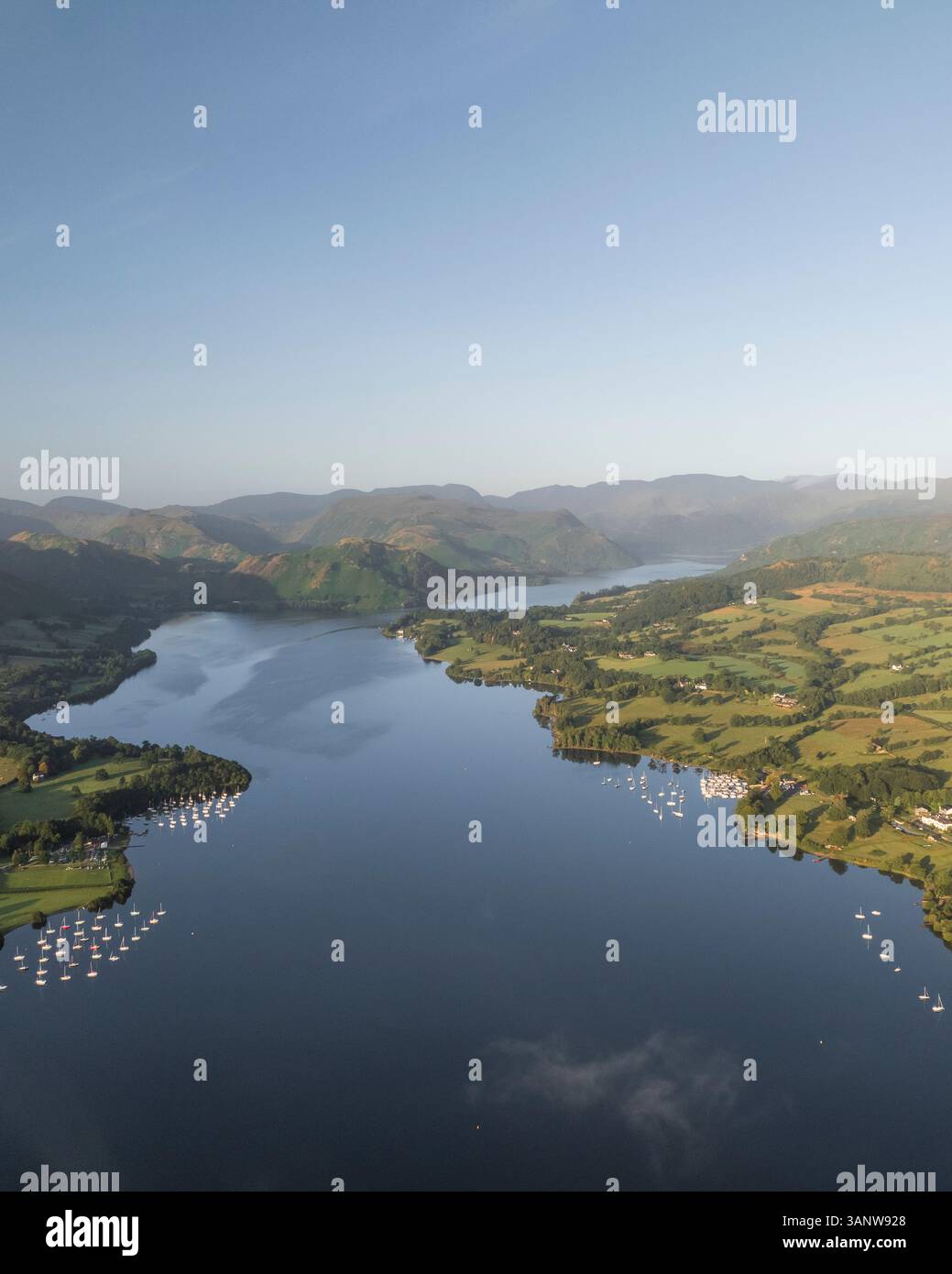 Aerial view of serene Ullswater lake surrounded by majestic mountains ...