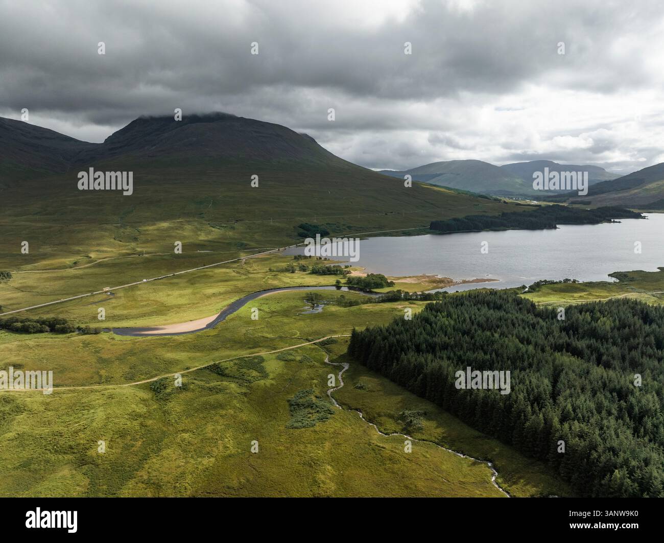 Aerial view of Loch Tulla surrounded by majestic mountains and lush ...