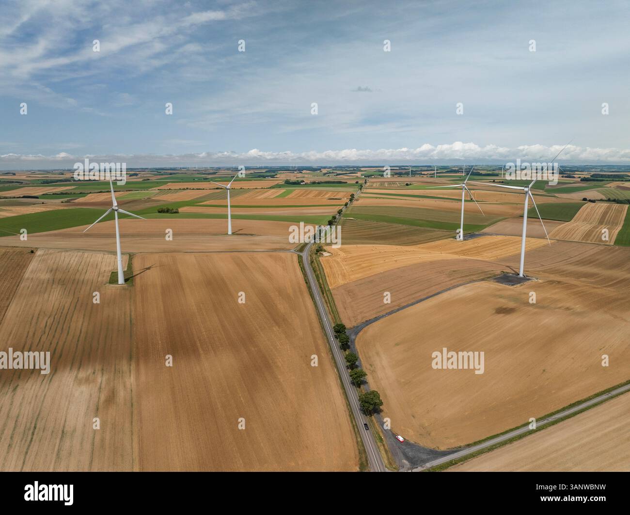 Aerial view of wind turbines amidst green fields and rural landscape ...