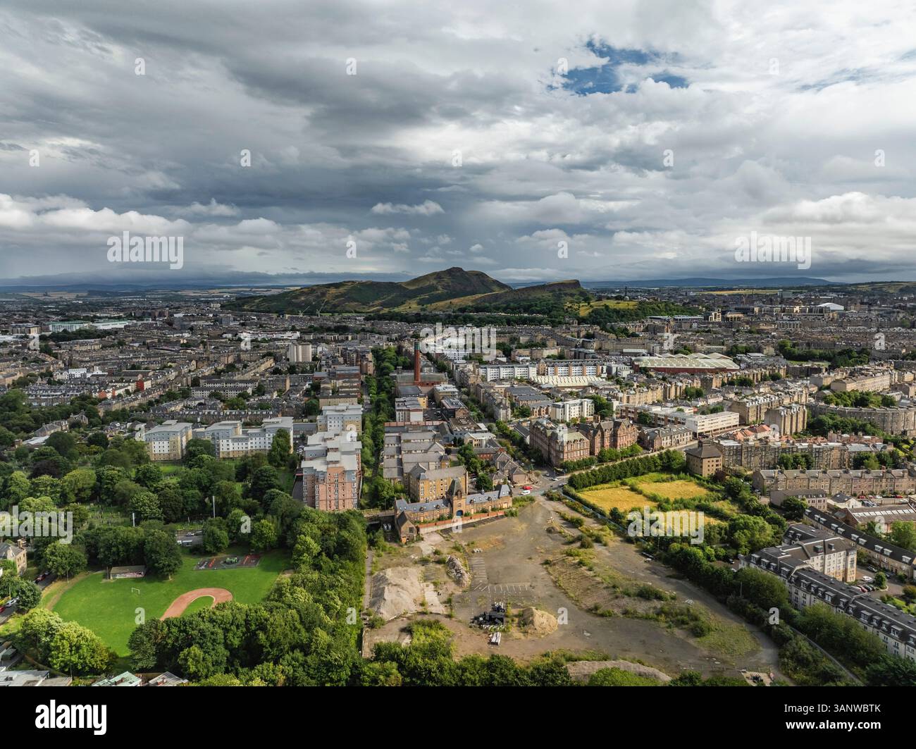 Aerial view of arthur seat volcano surrounded by urban buildings and ...