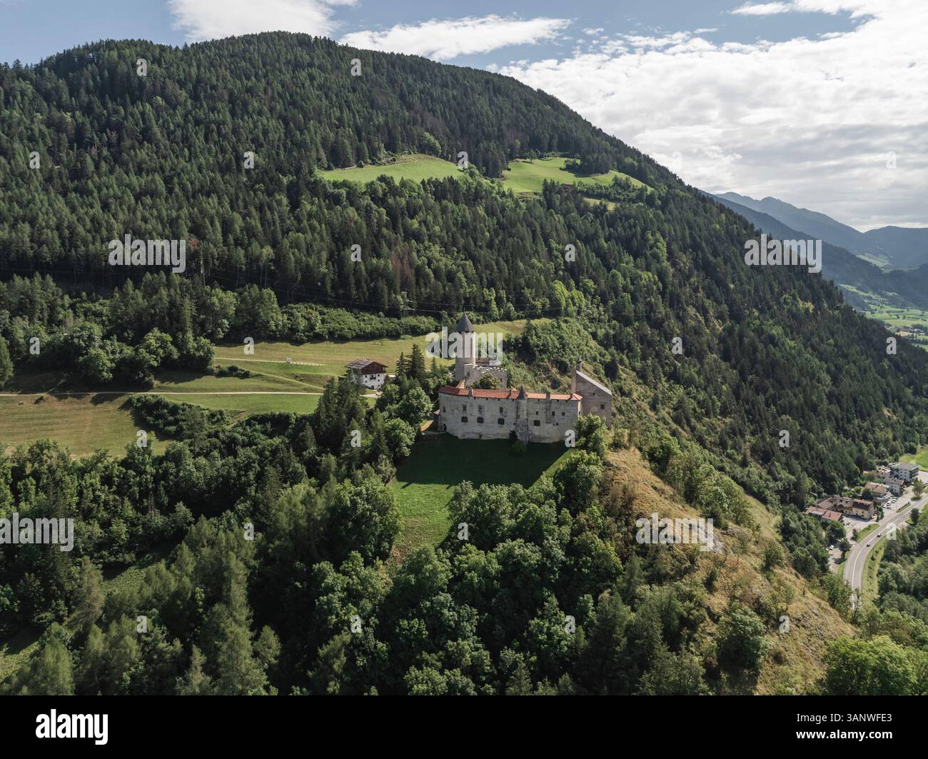 Aerial view of the historic CastelPietra castle surrounded by lush ...