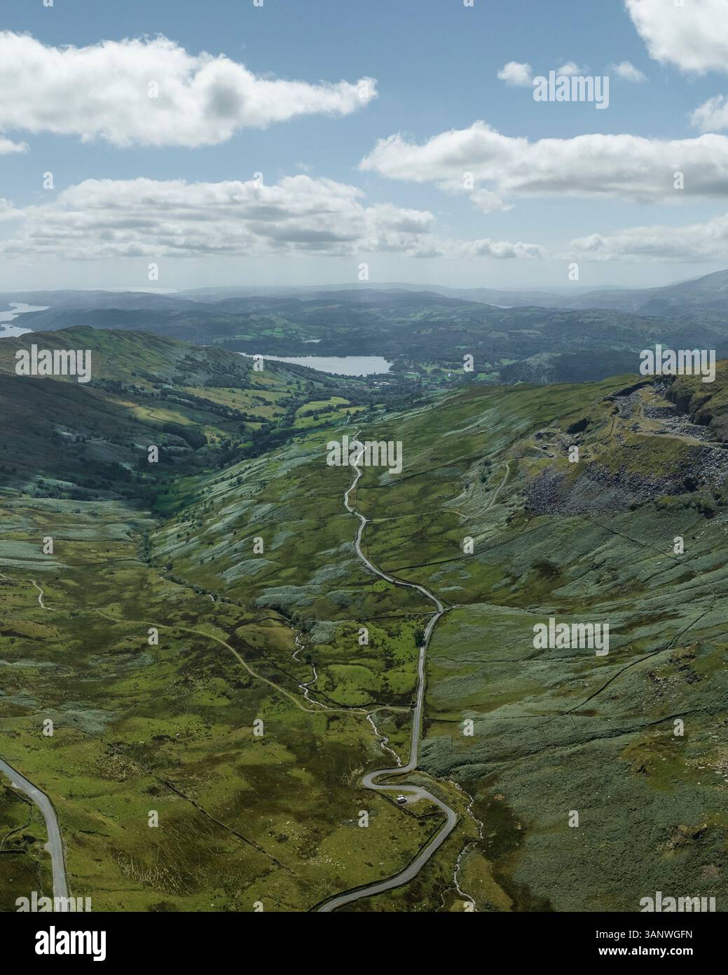 Aerial view of kirkstone pass with winding road through lush hills and ...