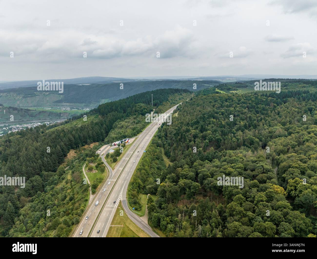 Aerial view of winding highway through lush forest and serene ...
