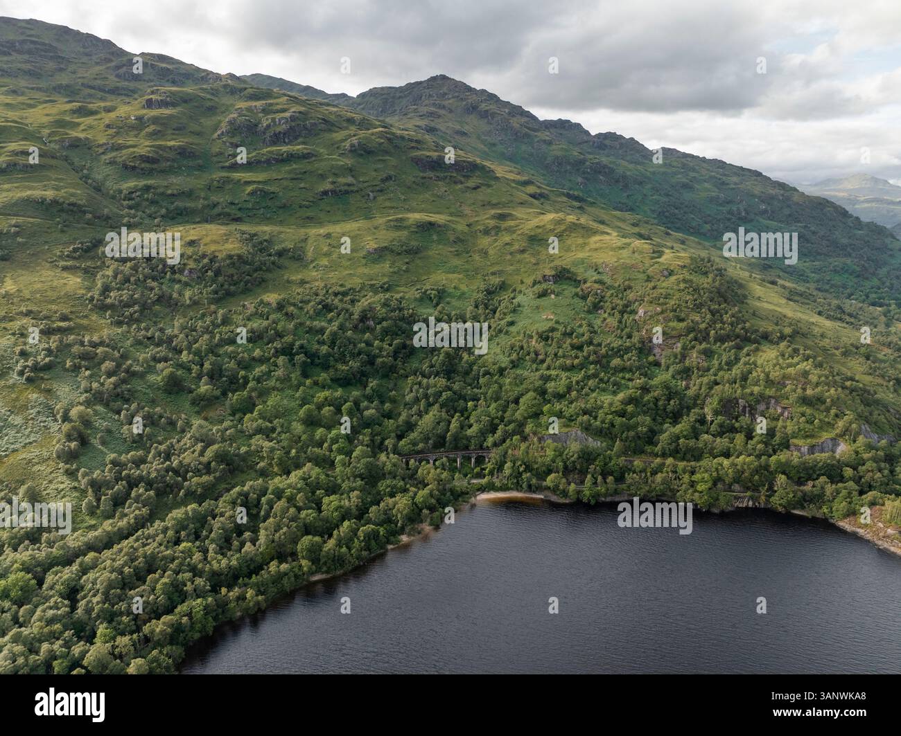 Aerial view of Loch Lomond surrounded by majestic mountains and lush ...