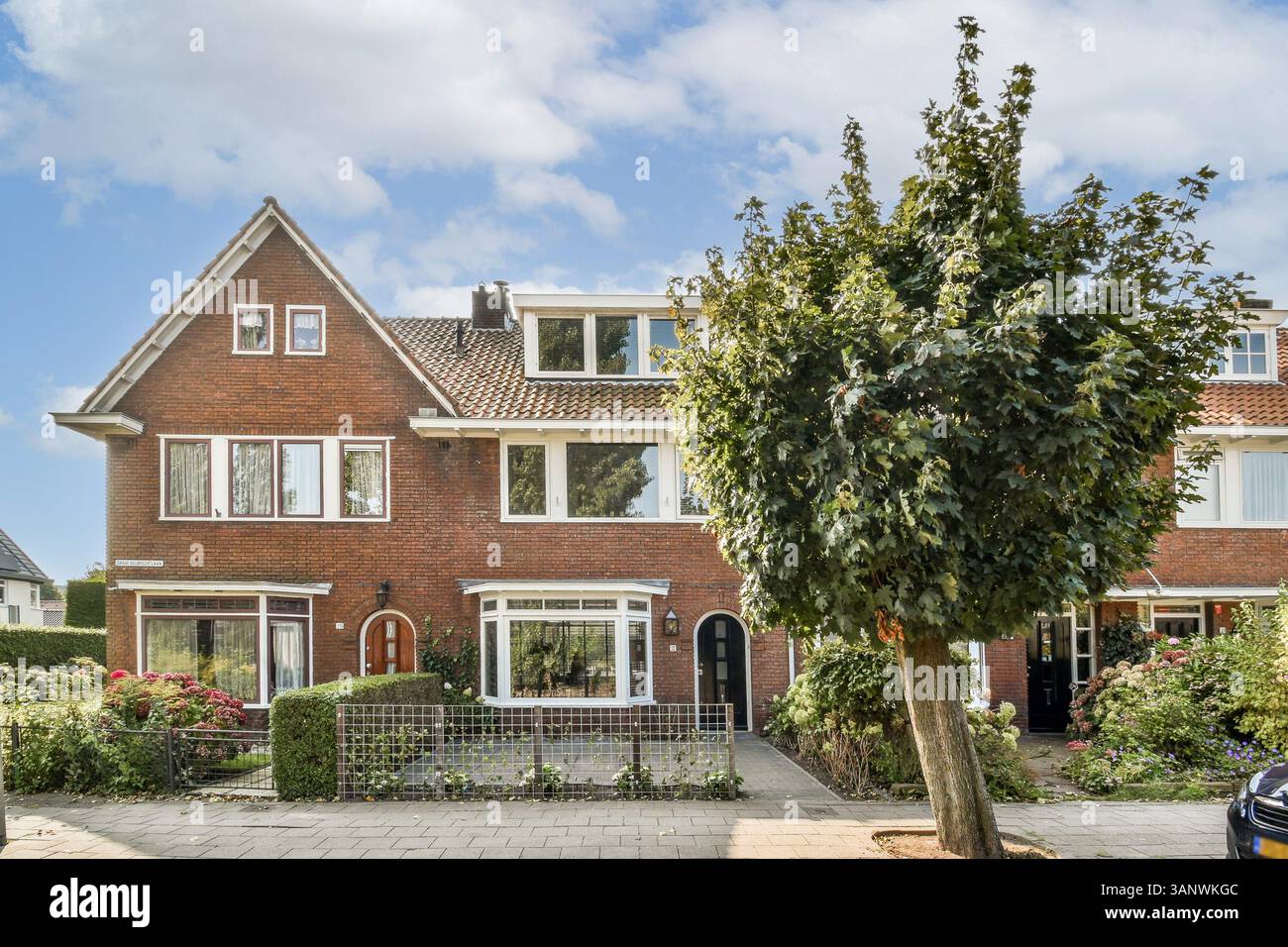 A picturesque residential building featuring a vibrant garden and ...