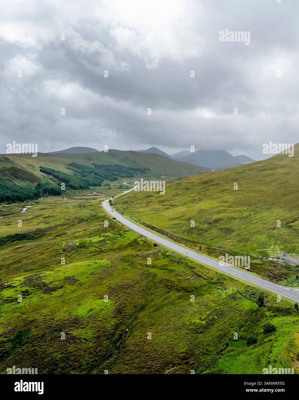 Aerial view of winding road through lush green valleys and majestic ...